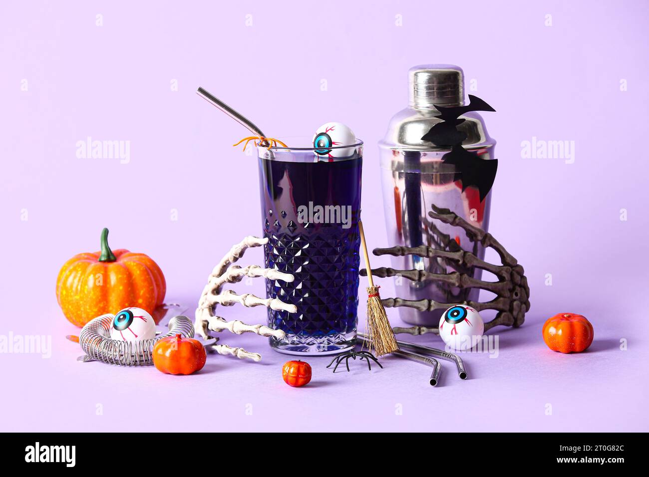 Glass of delicious cocktail, skeleton hands and pumpkins for Halloween ...