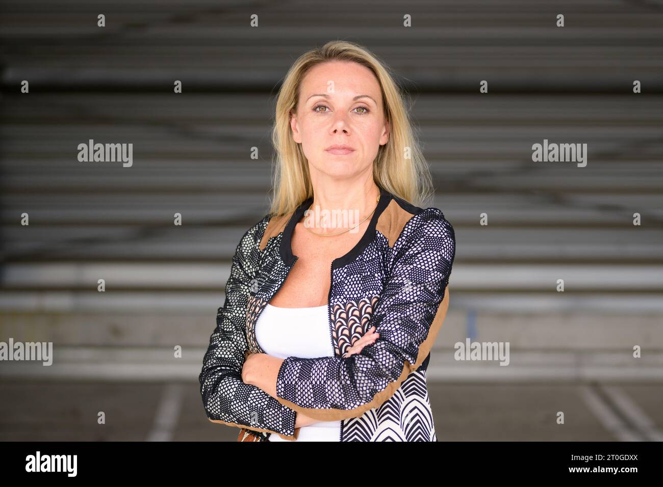 Upper Body Portrait Of An Attractive Blonde Woman With Arms Crossed