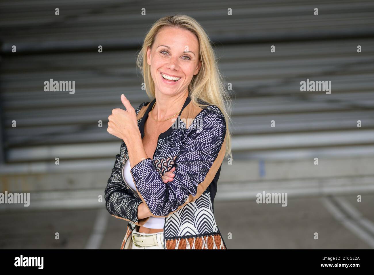 Upper body portrait of an attractive blonde woman smiling at the camera ...