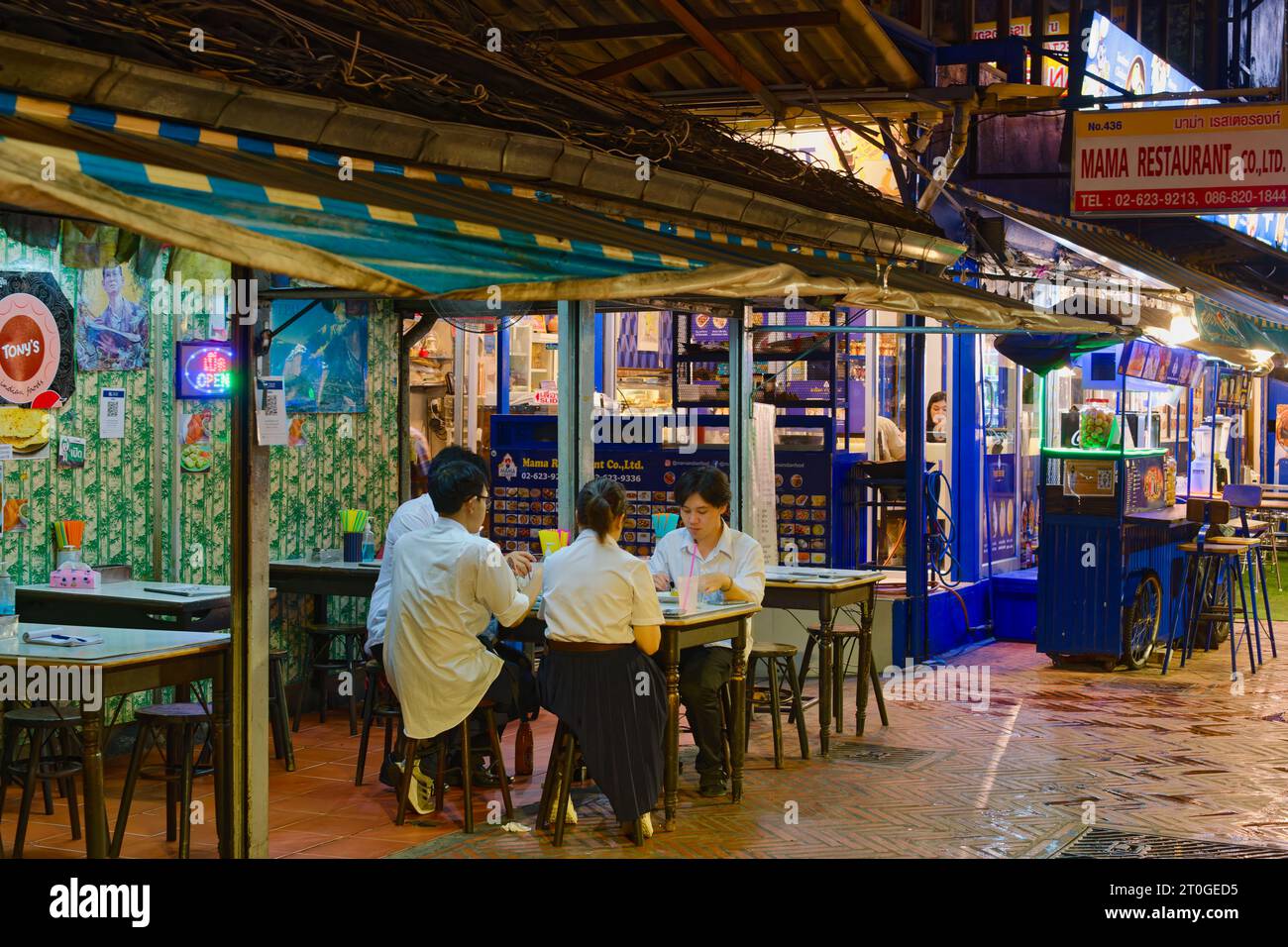 Thai students eating at night at an Indian restaurant at Klong Ong Ang ...