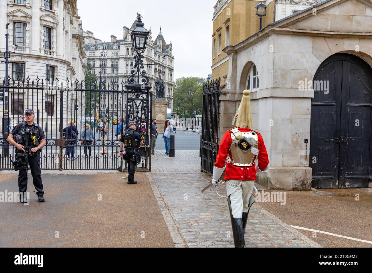 Horse Guards trooper in ceremonial dress walks towards near to armed ...