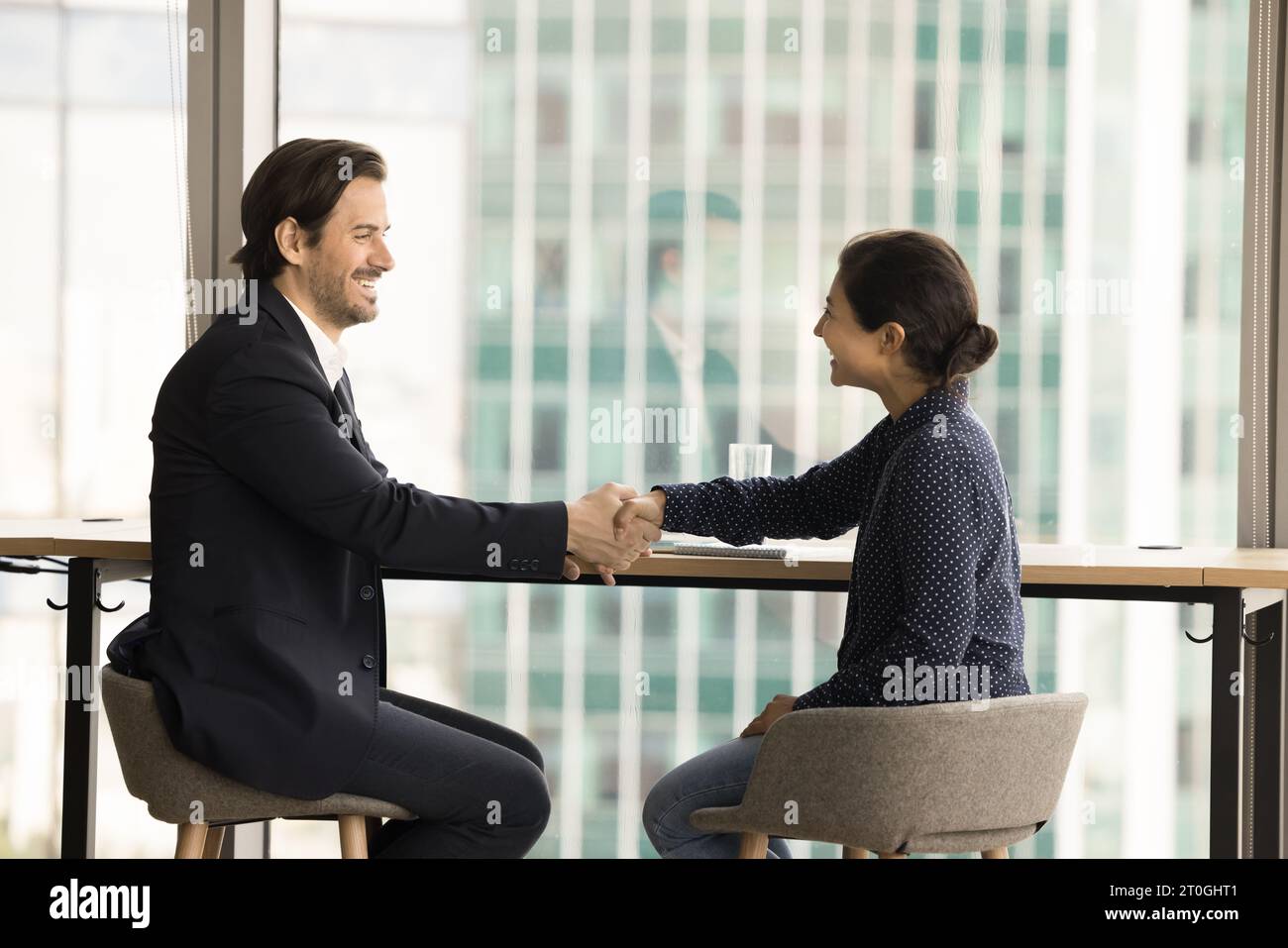 Happy multiethnic colleagues couple closing agreement with handshake ...