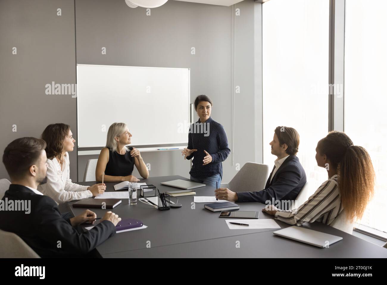 Confident young Indian manager presenting project report to diverse ...