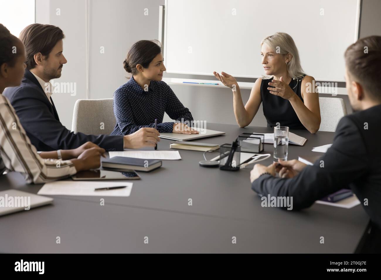 Serious mature coach, mentor woman training diverse staff Stock Photo ...