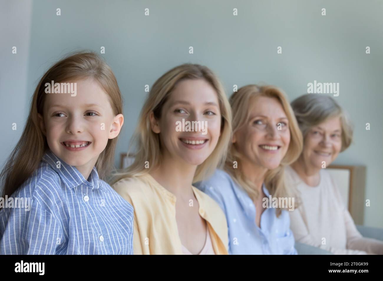 Cheerful girls and women of four female generations posing indoors ...