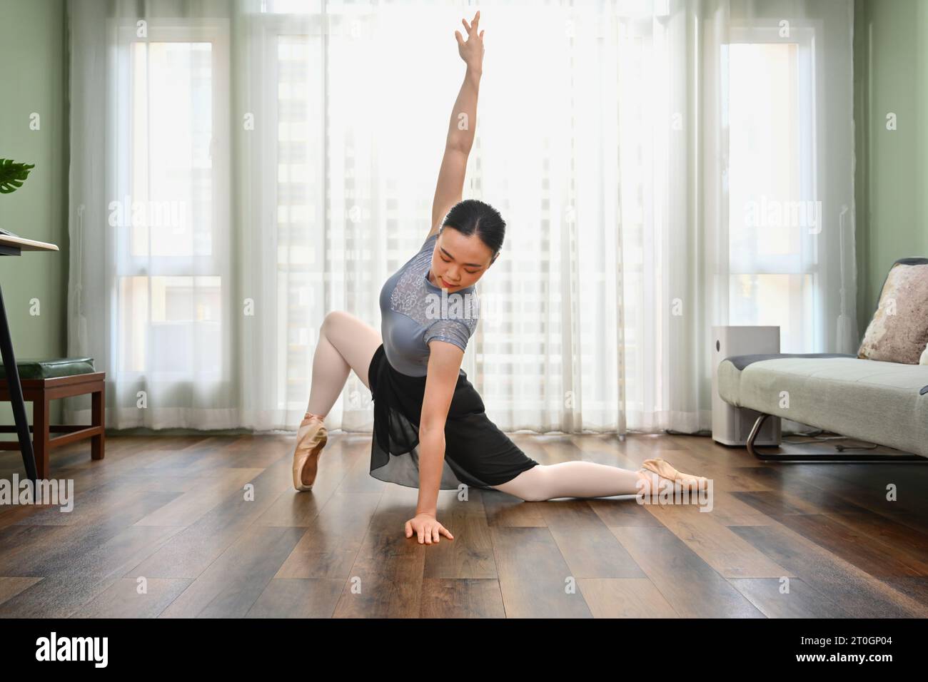 Beautiful woman in pointe shoes practicing ballet at home. People ...