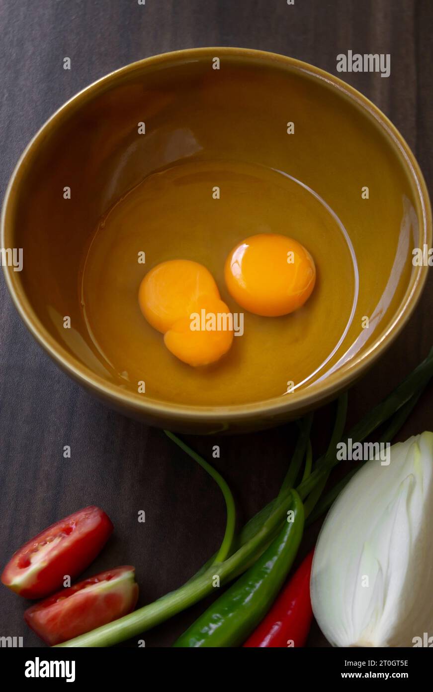 Fresh natural eggs in a bowl with spring onions and coriander to ...