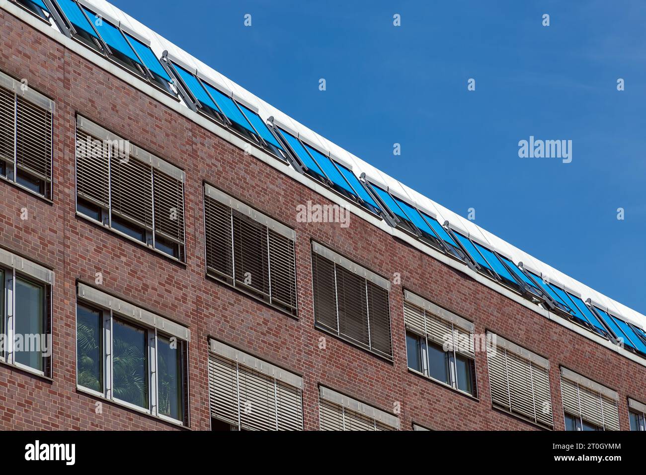 Office building with brick facade and sun protection on the windows ...