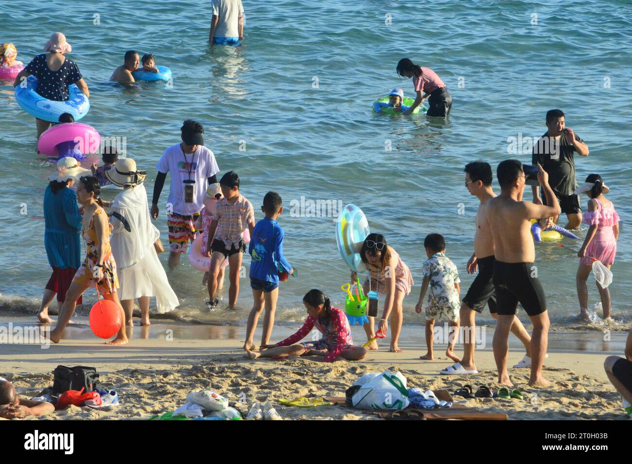 Tourists play at the seaside during the National Day holiday in Sanya ...