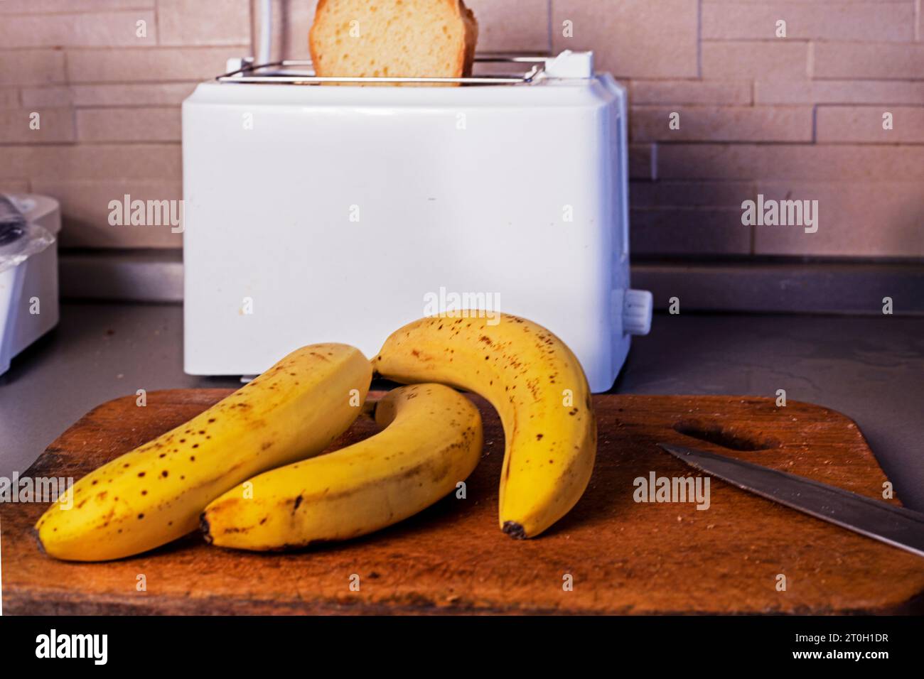 bunch of ripe bananas in the kitchen near the toaster. breakfast Stock ...