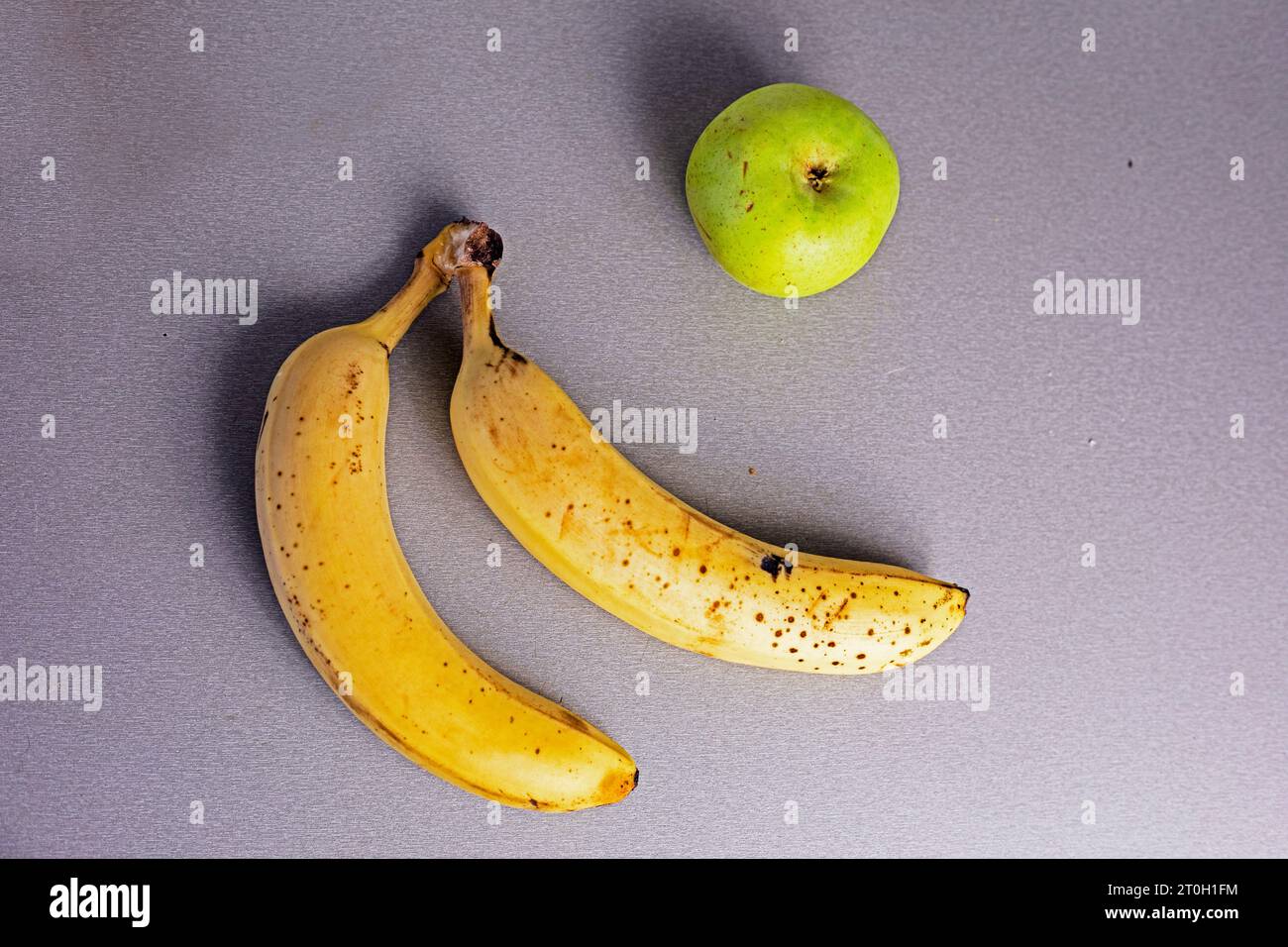 ripe bananas with green apple on a gray table. flatlay Stock Photo - Alamy