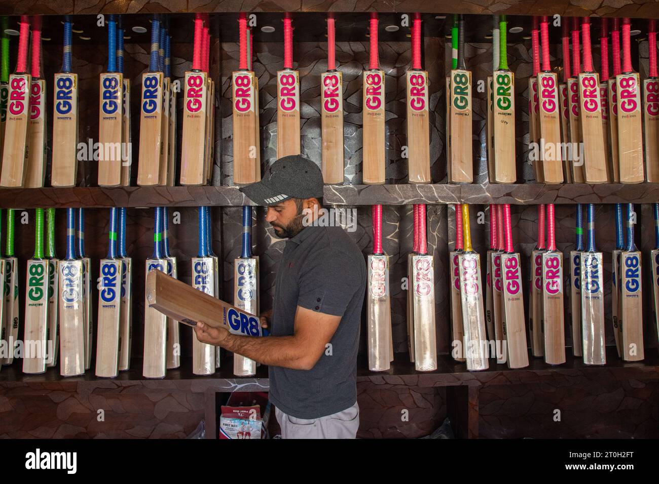 A customer checks finished Kashmiri willow wood bats inside a showroom ...