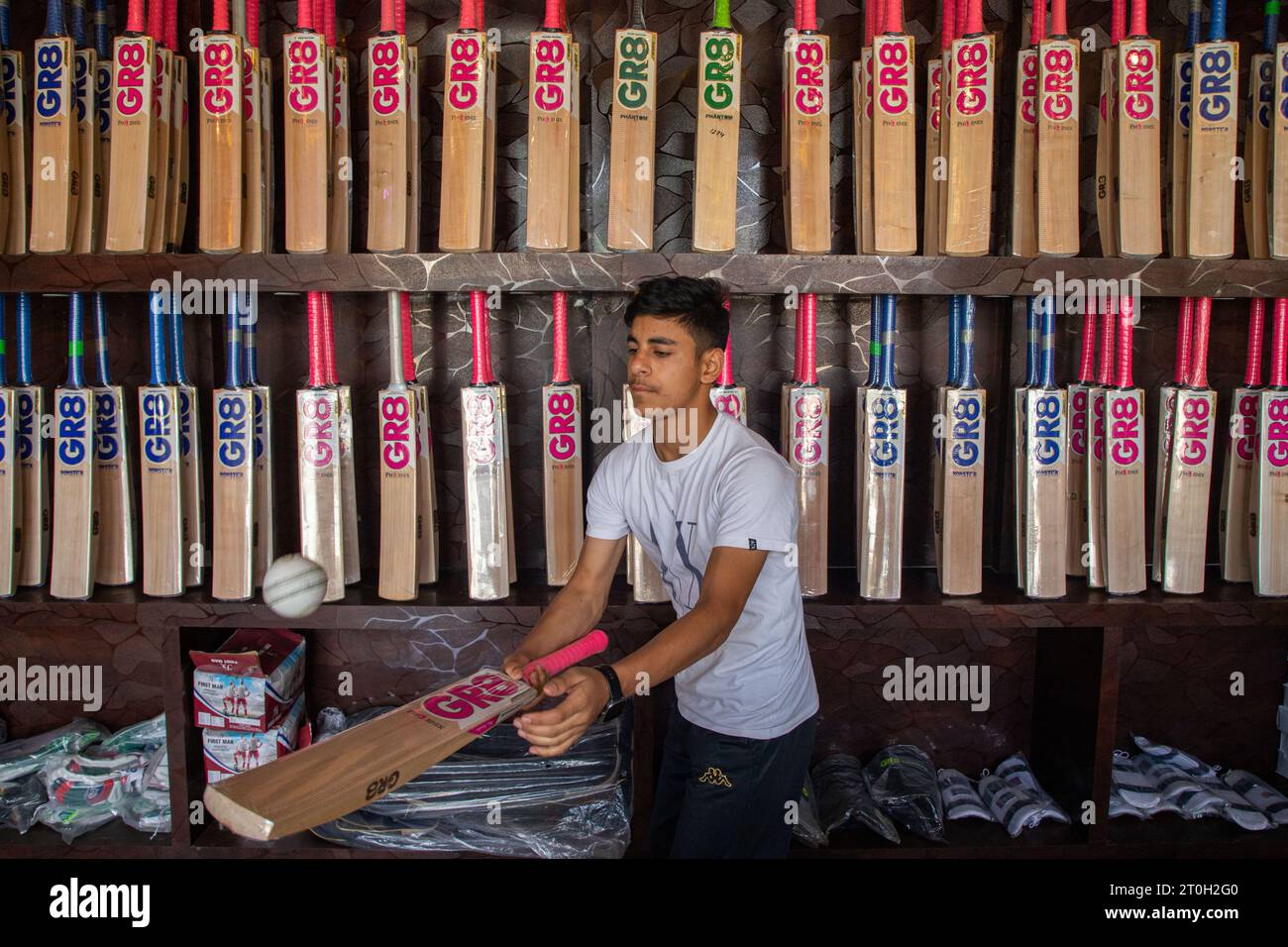 A customer checks finished Kashmiri willow wood bats inside a showroom ...