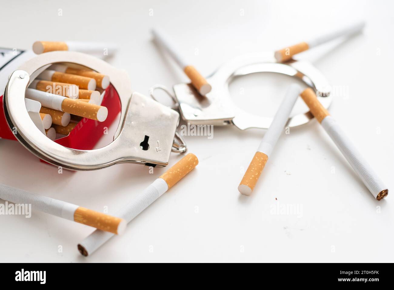 Heap of cigarettes locked to handcuffs Stock Photo - Alamy