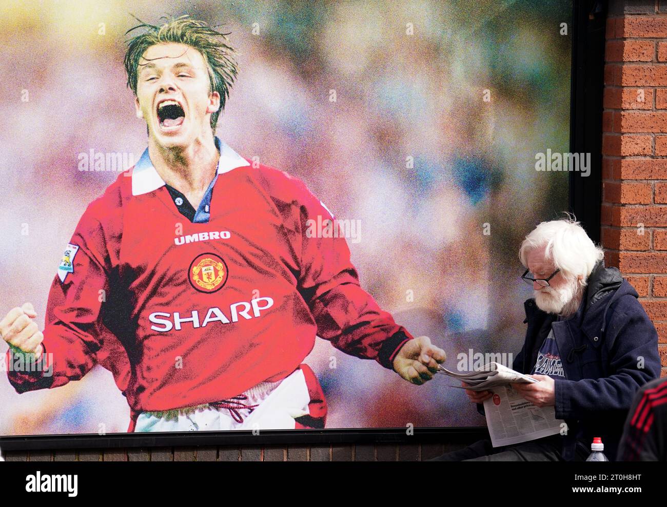 A fan reads a newspaper next to an image of former Manchester United ...
