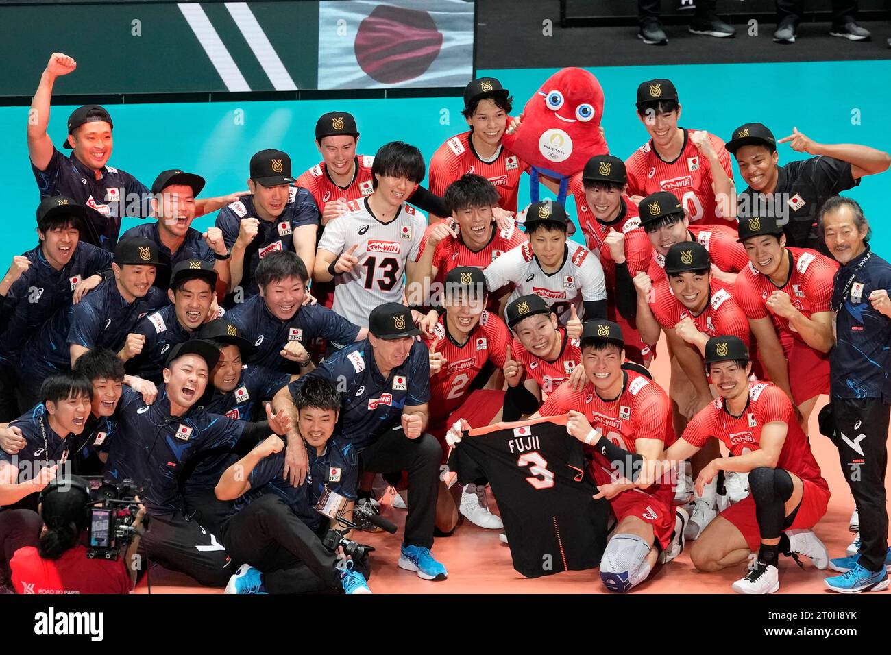 Japanese men's volleyball team and team staff pose for a photo as the ...