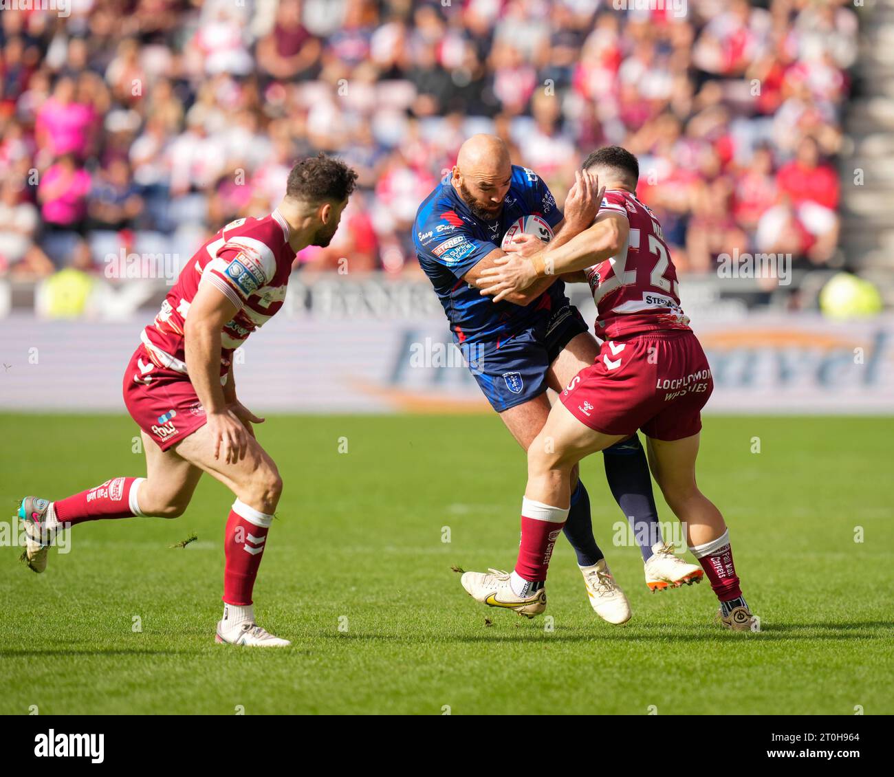 Kane Linnett #12 of Hull KR runs at Abbas Miski #23 of Wigan Warriors ...