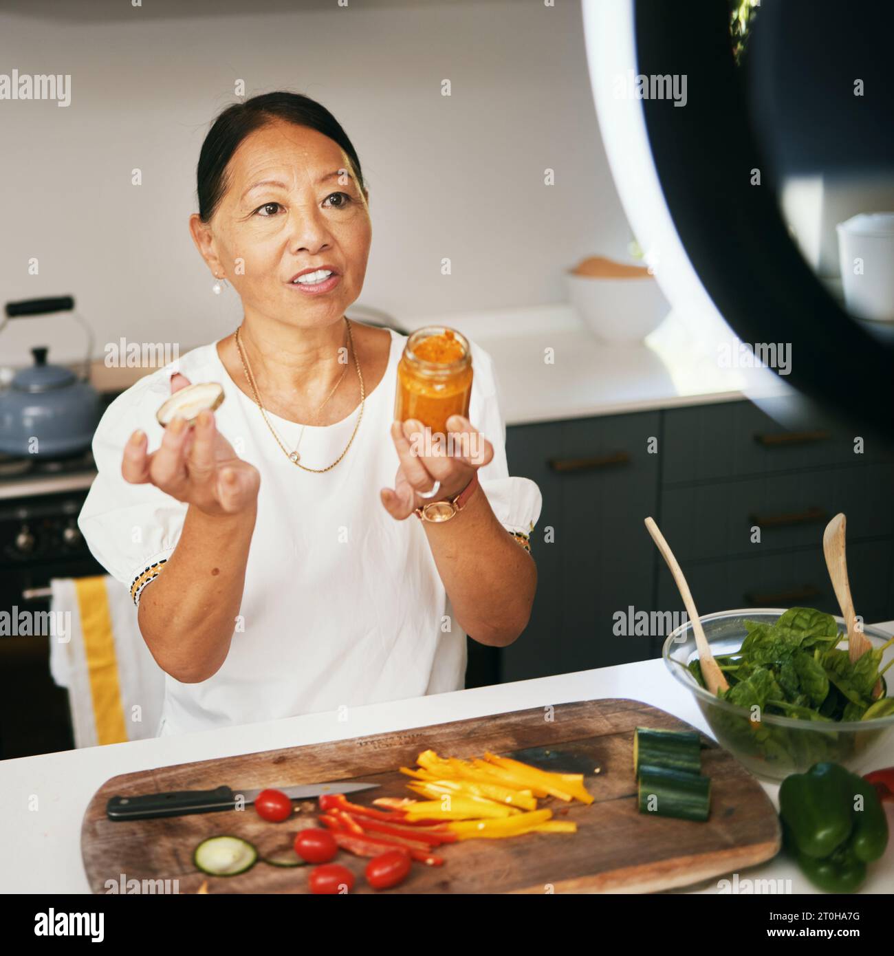 Asian woman, vegetables and live streaming for cooking with bottle ...