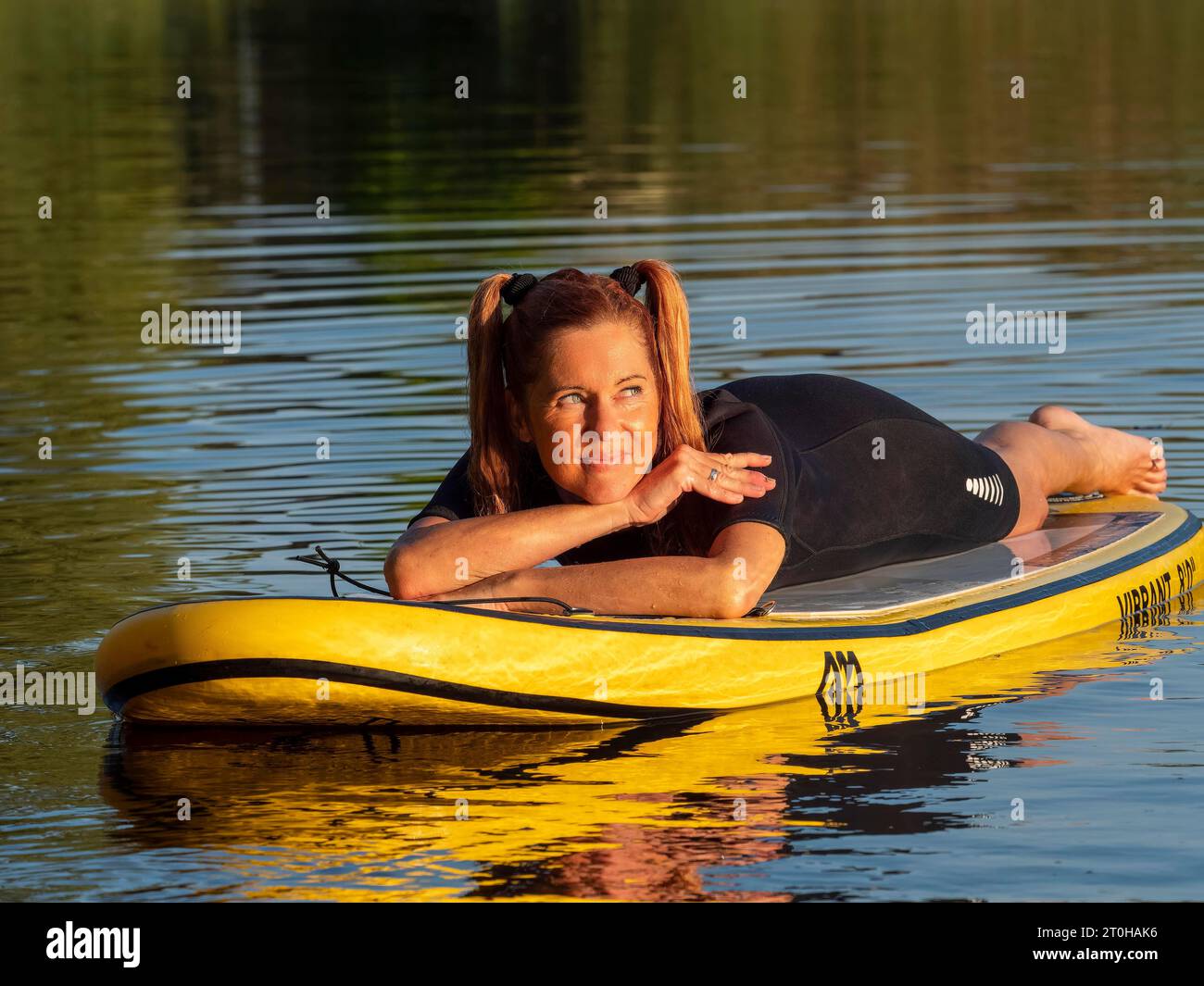 Woman lying on paddle board hi-res stock photography and images - Alamy