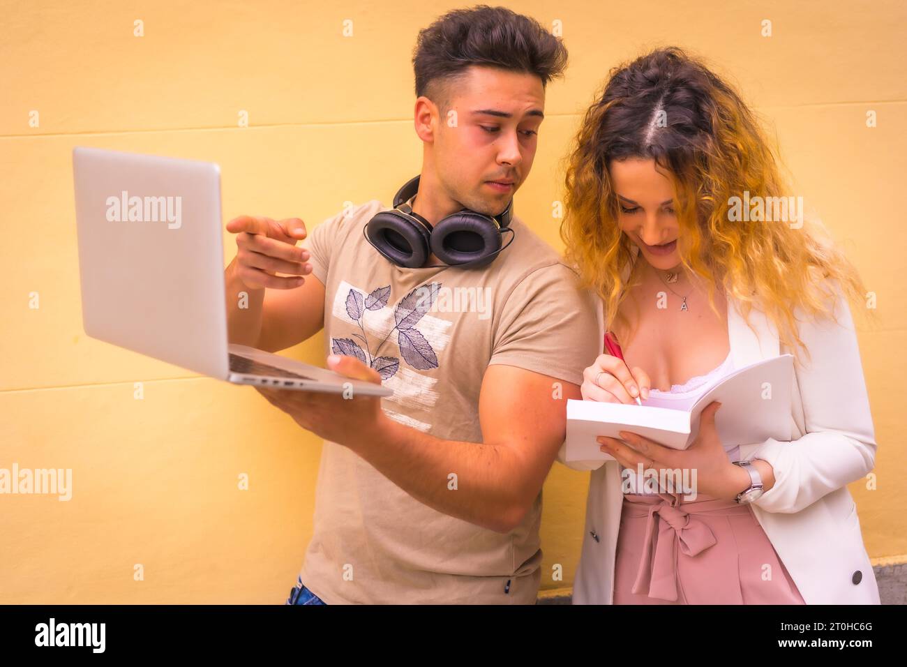 Young entrepreneur couple doing teamwork with a computer. With a yellow ...