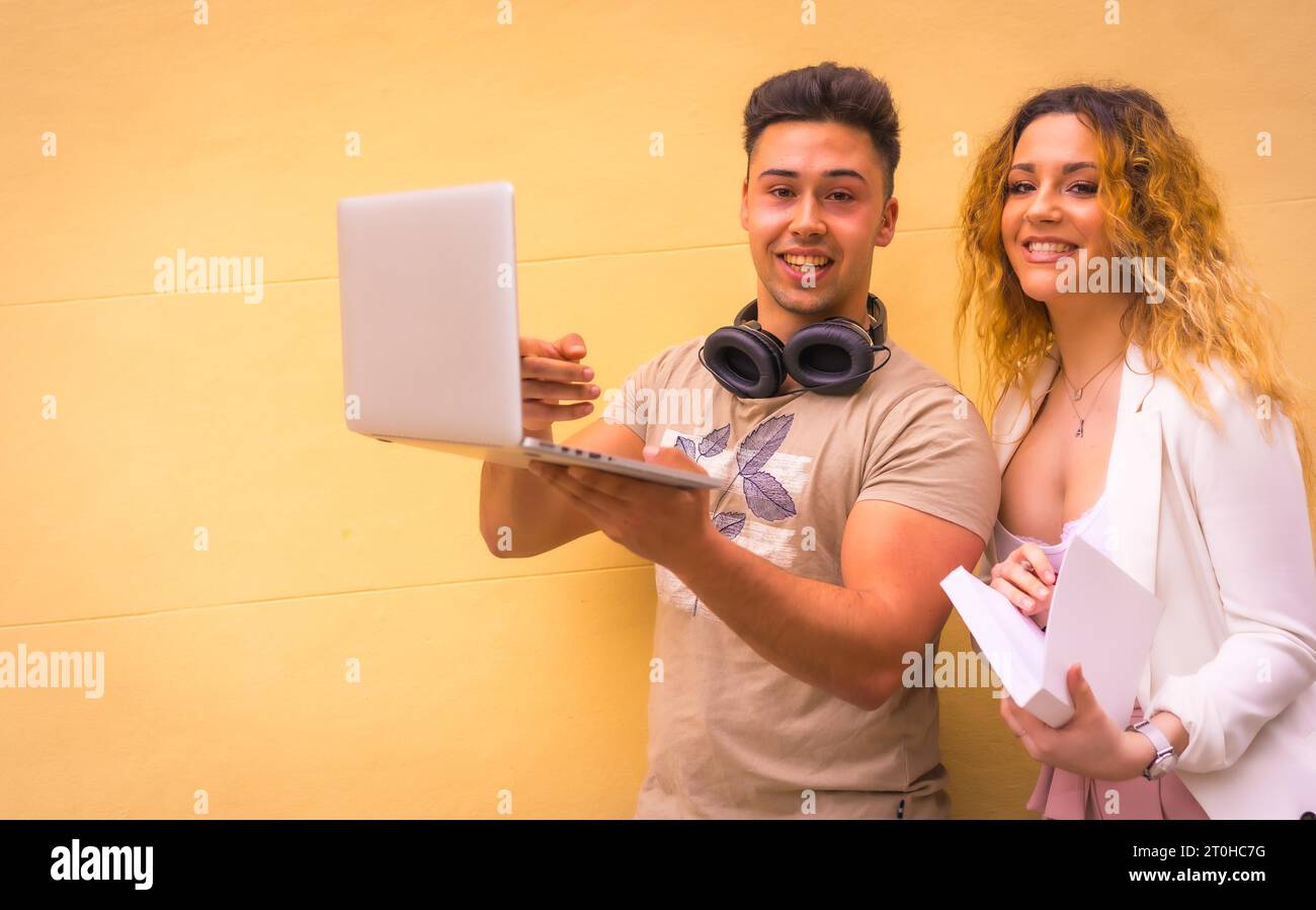 Young entrepreneur couple doing teamwork with a computer. With a yellow ...