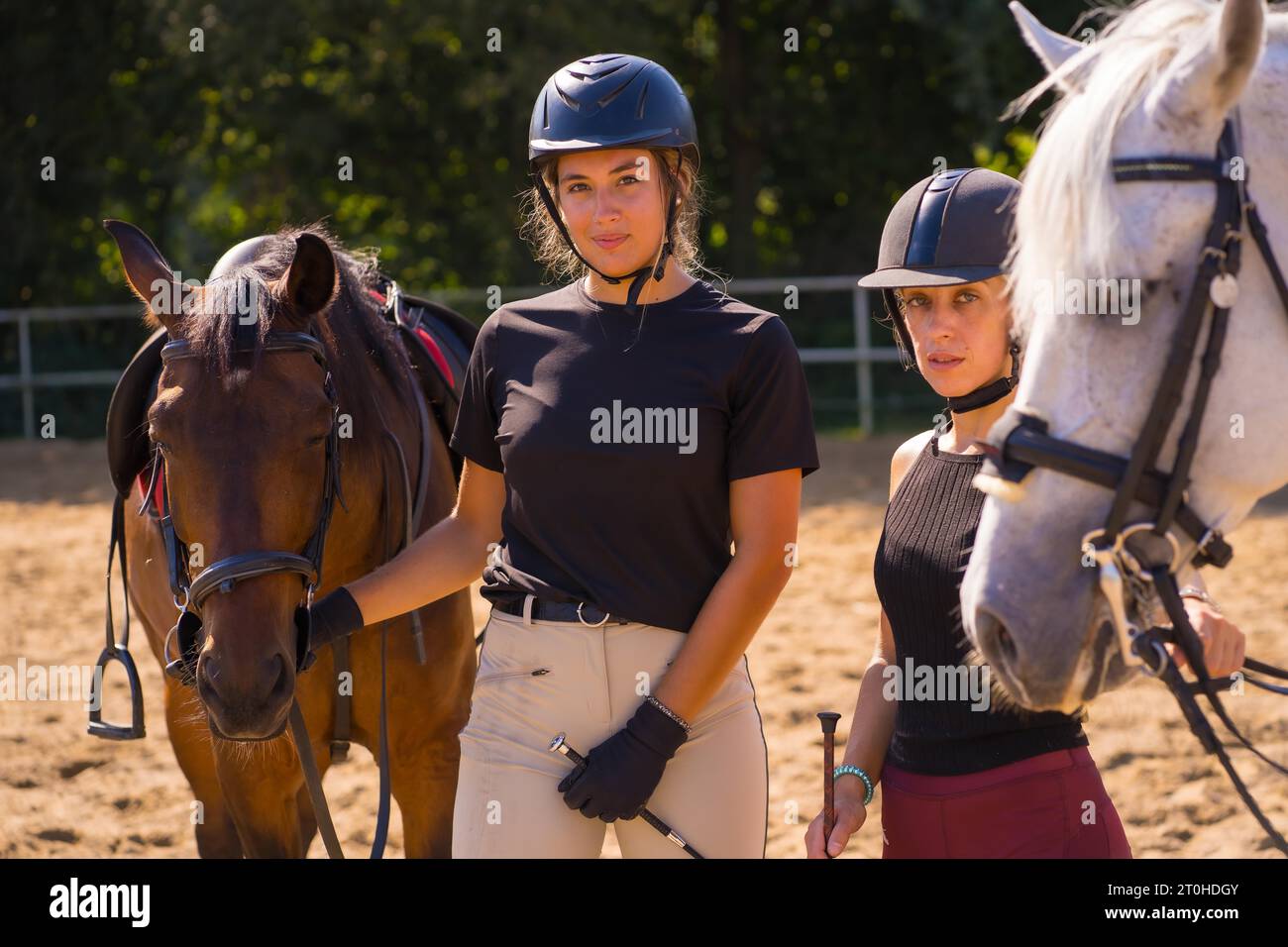 Two young Caucasian girl riders having fun with their white and brown ...