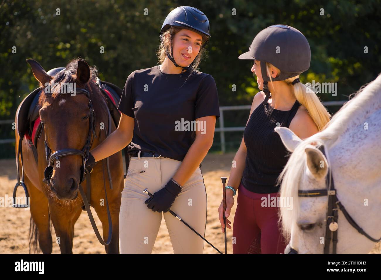 Two young Caucasian girl riders having fun with their white and brown ...
