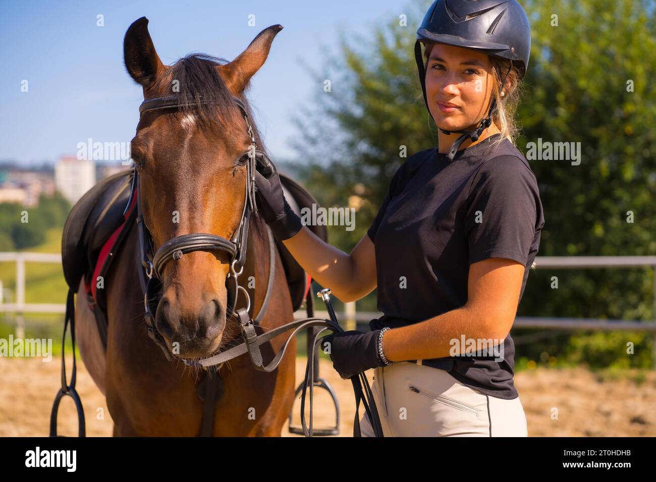 Posing of a Caucasian blonde girl on a horse caressing and pampering a ...