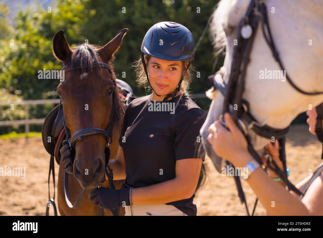 Posing of two young Caucasian girls riders with their white and brown ...