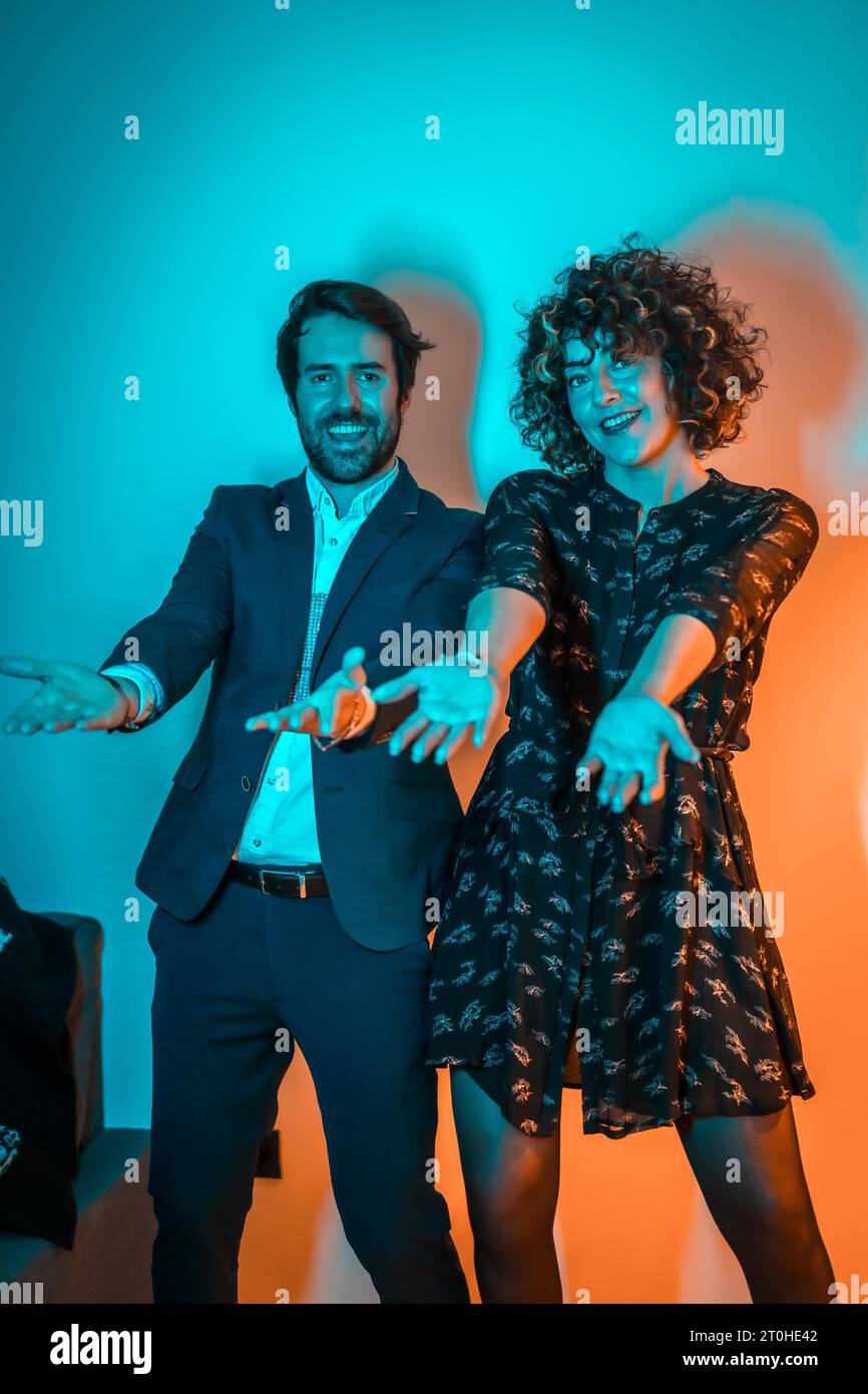Party lifestyle, a very happy couple dancing at a party with blue and ...