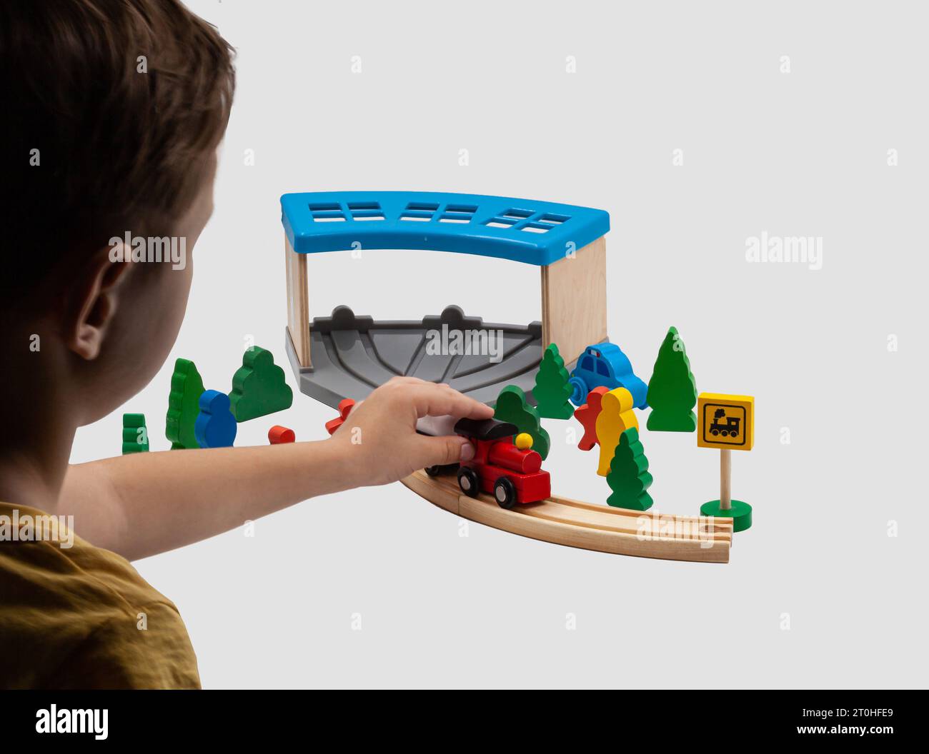 Boy playing with toys. Children's toy train with two cars on wooden ...
