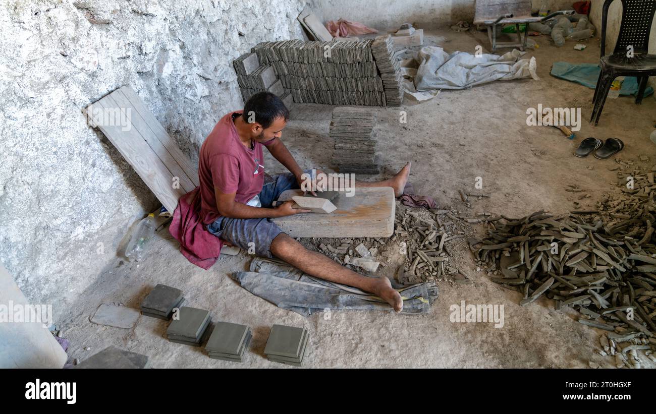 Fes, Morocco - 10 September 2022: Moroccan craftsman cutting tiles into ...