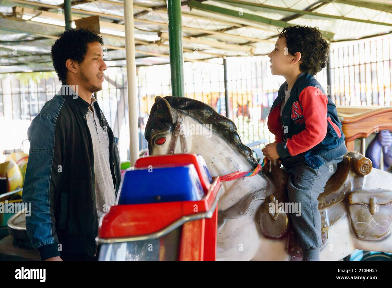 Venezuelan Latino male child, happy riding on pretend horse with his ...