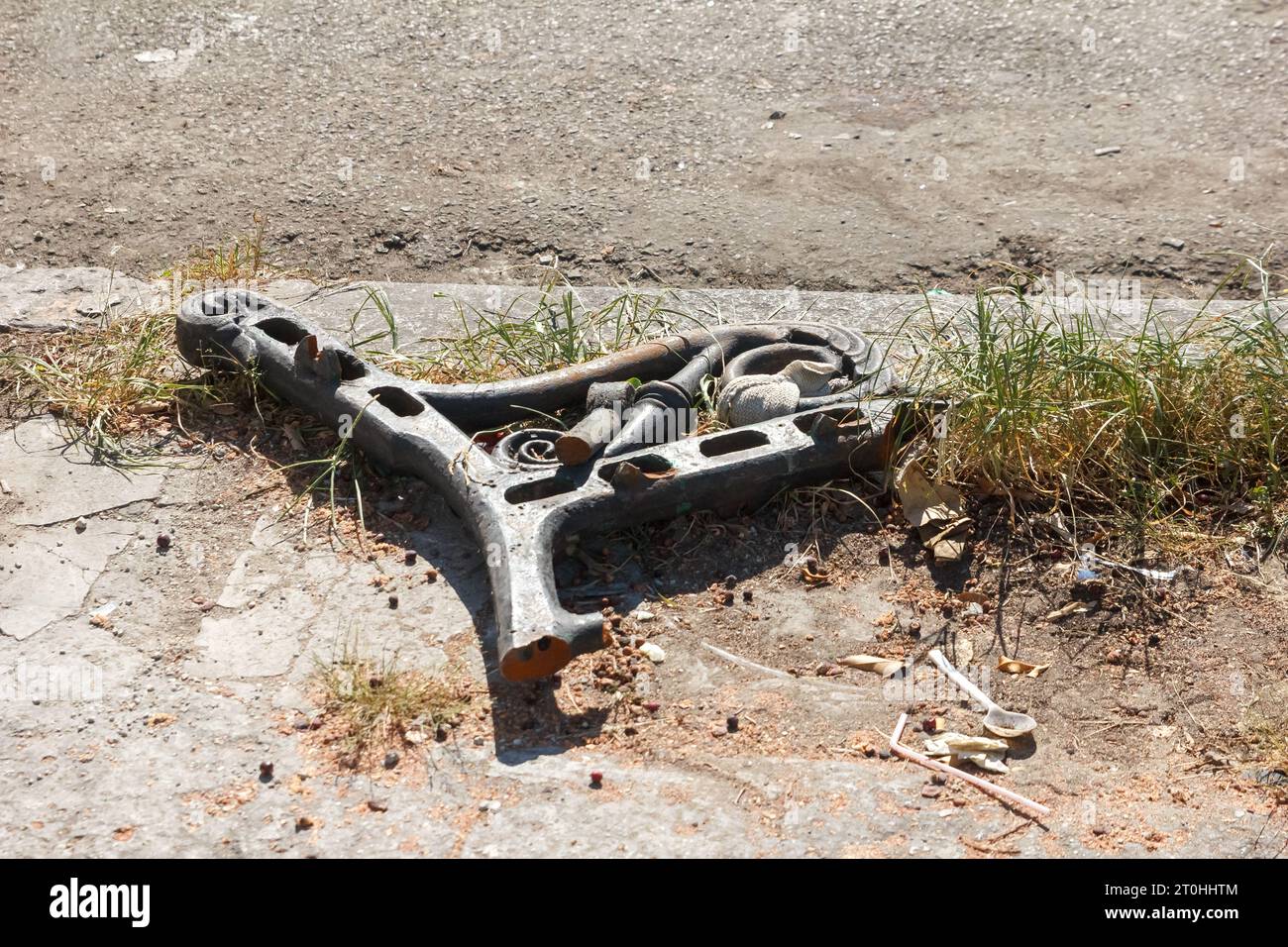 Part of a broken city bench abandoned in the sidewalk. Symbol of ...