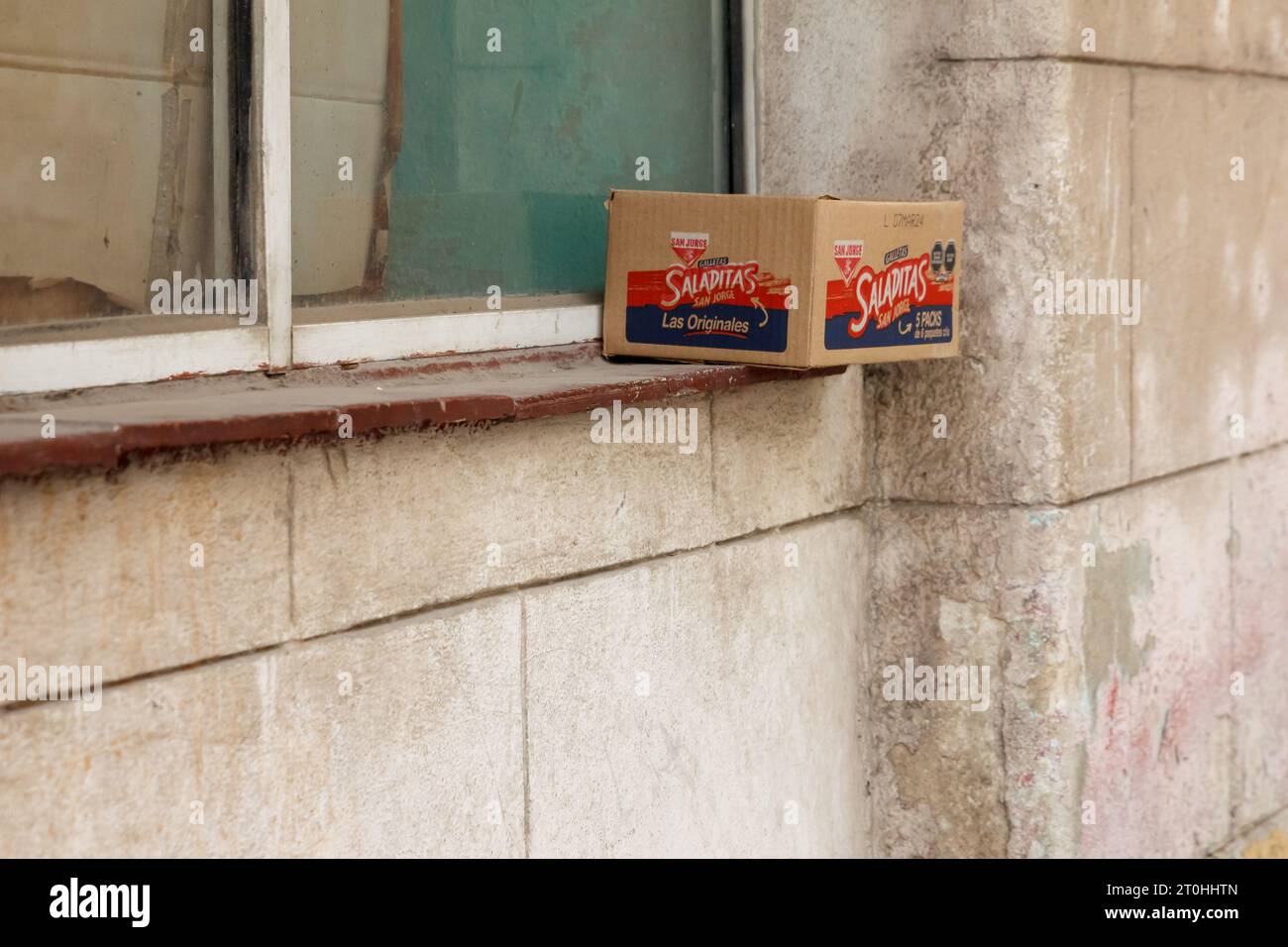 A carboard box container is abandoned in a window of a weathered ...