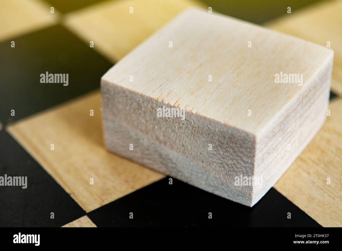 Side view closeup of wooden cube on empty chess board Stock Photo - Alamy