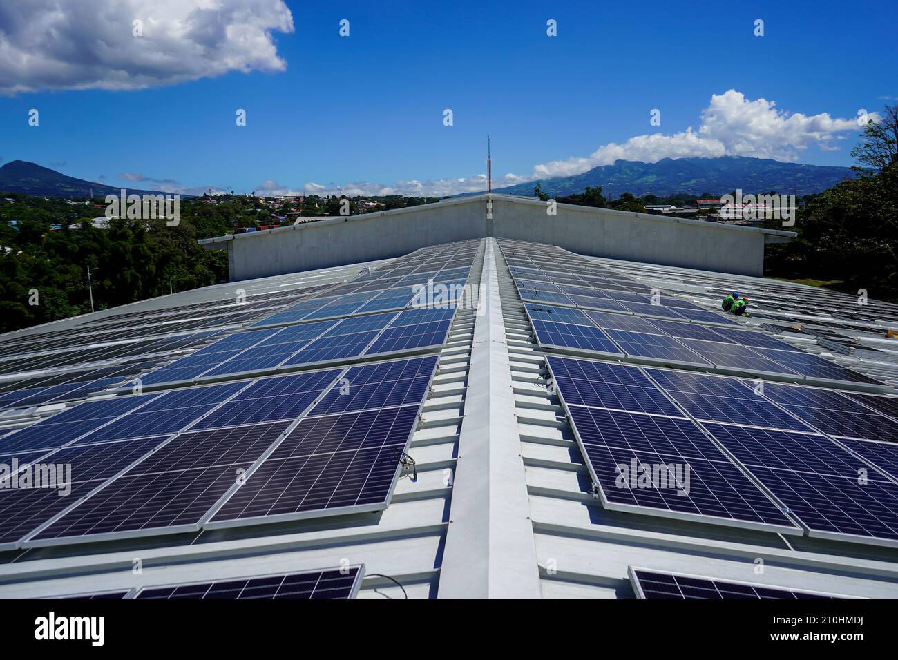 View of the installation of solar panels on a warehouse roof -green energy - renewable energy ...