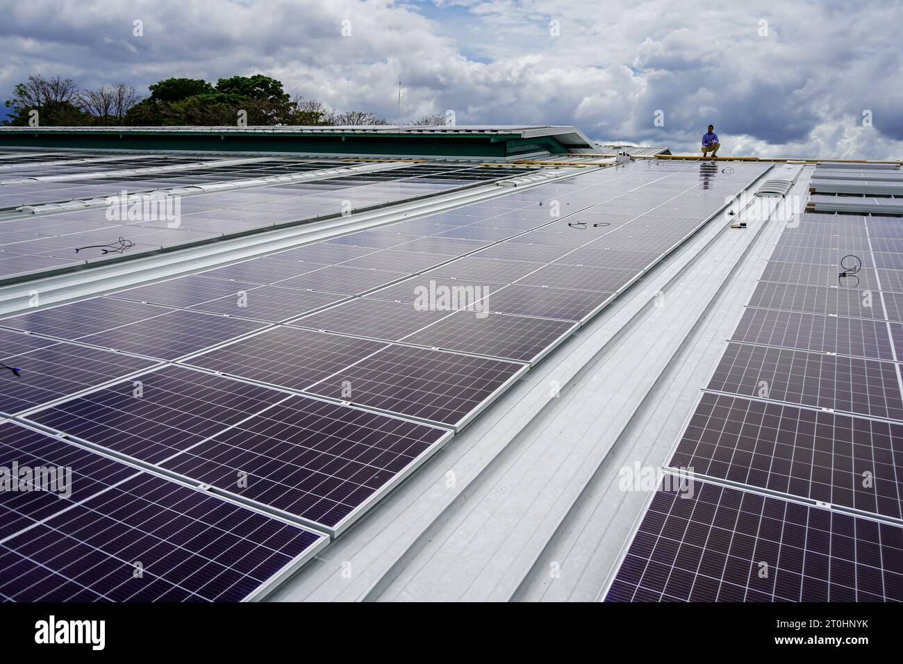 View of the installation of solar panels on a warehouse roof -green energy - renewable energy ...
