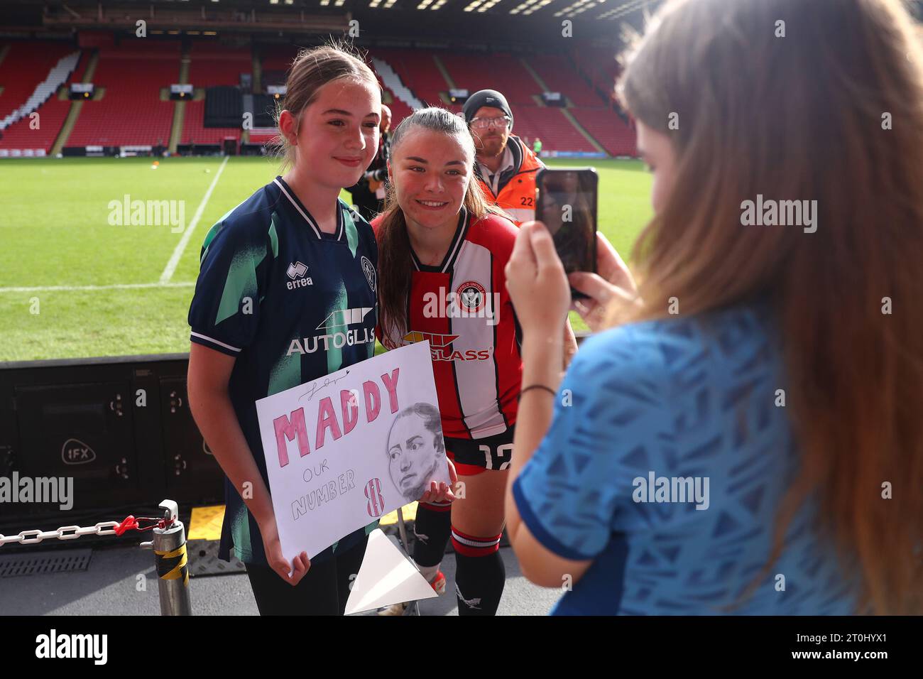 Sheffield United's Jodie Hutton poses for a photo with a fan holding a ...