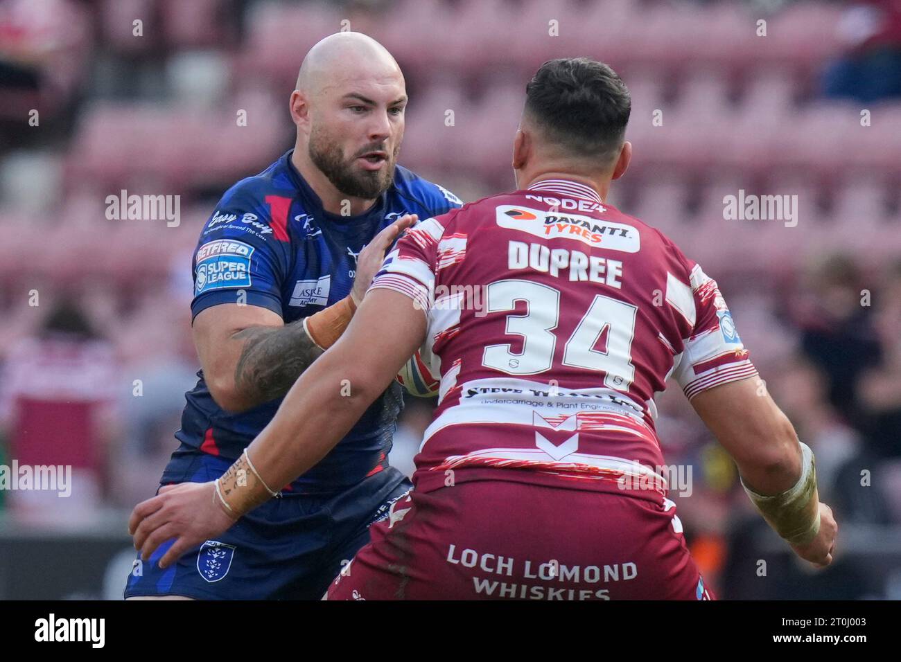 Sam Luckley #26 of Hull KR runs at Tyler Dupree #32 of Wigan Warriors ...