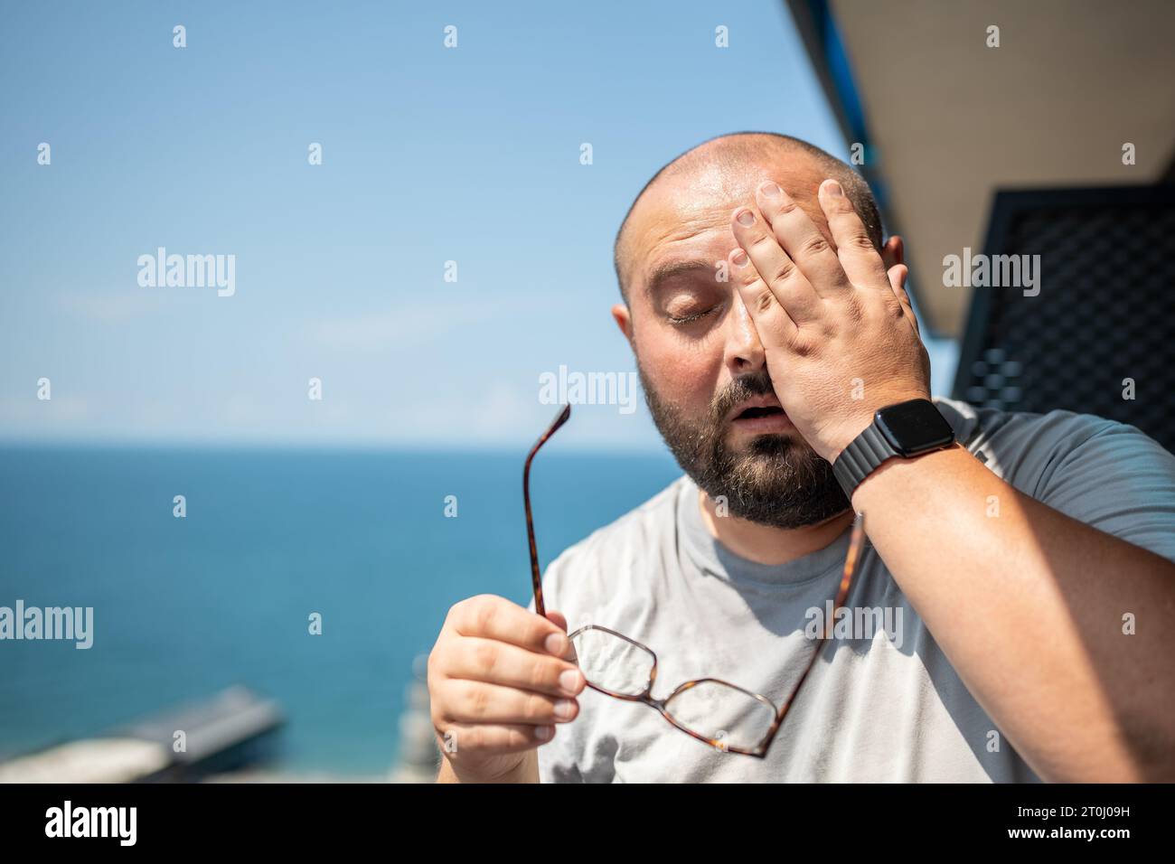Bald fat man drenched in sweat wiped off excess moisture. Sweating ...