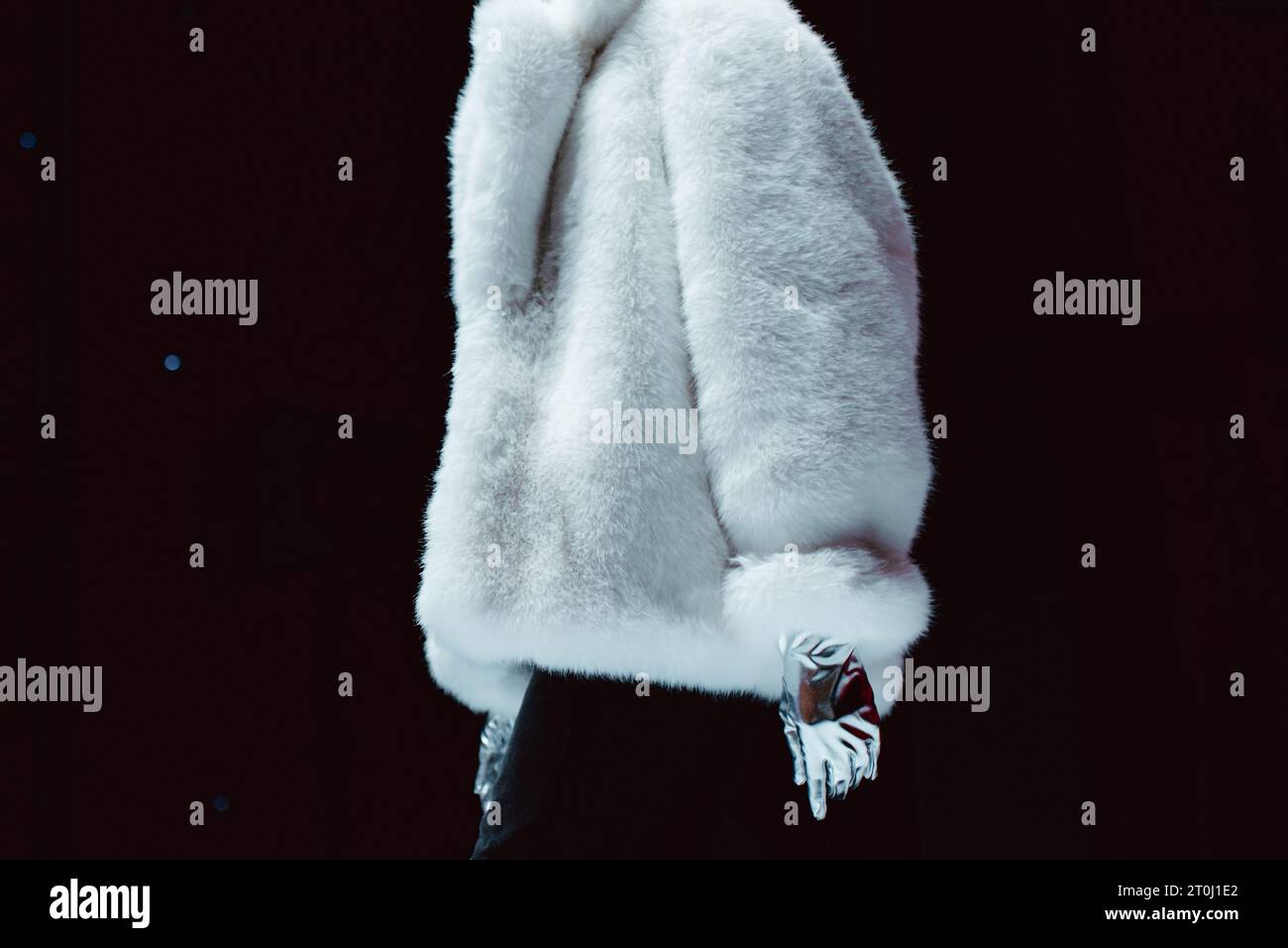 Fashion details of a white fluffy winter fur coat and silver gloves ...