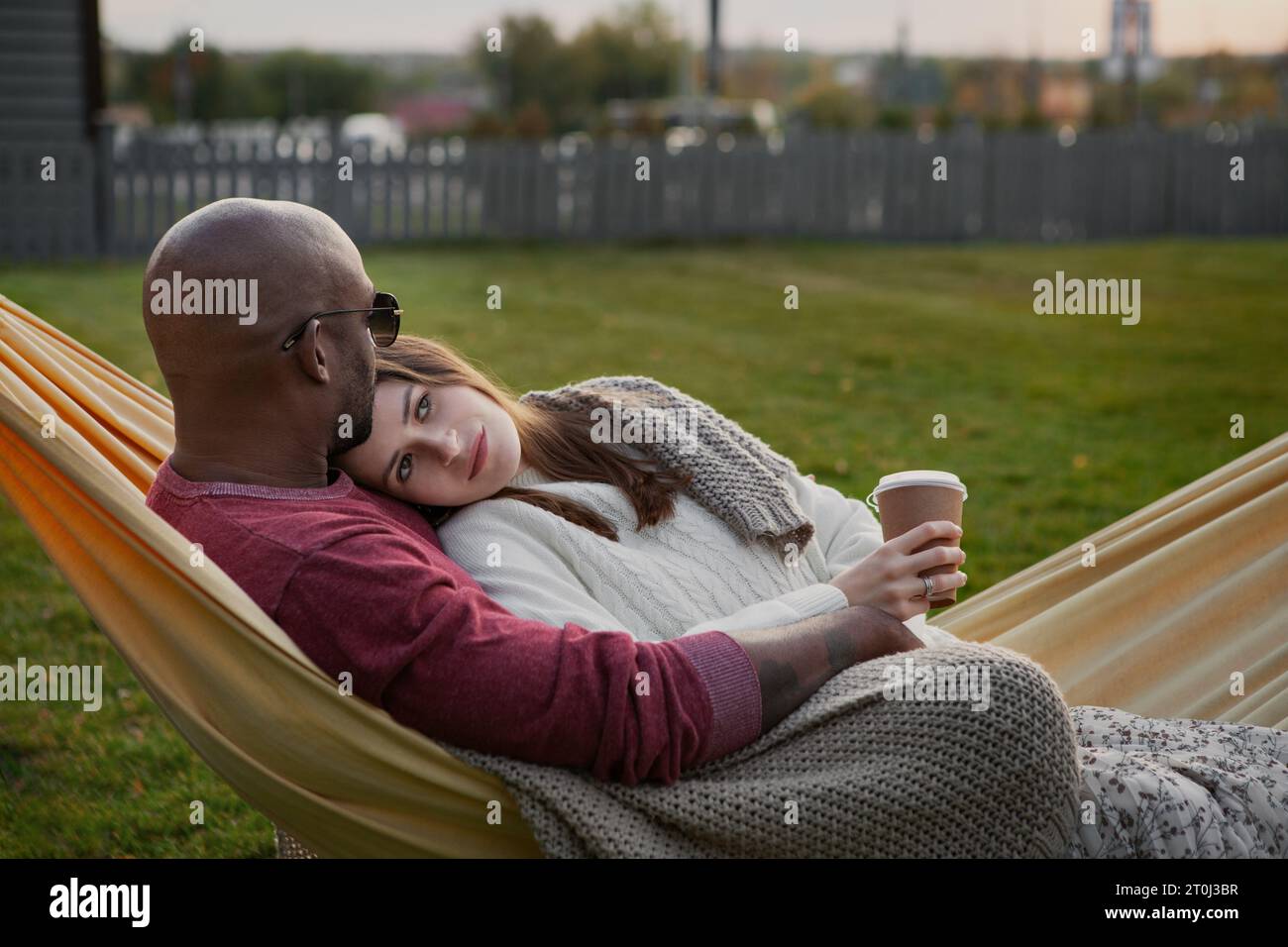 Beautiful couple in love, wrapped in cozy blanket, embracing while ...
