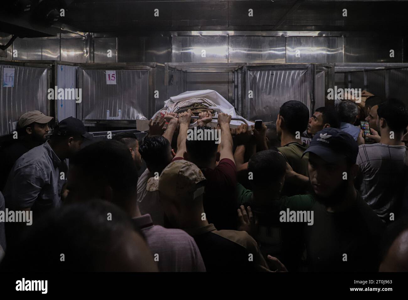 Gaza. 7th Oct, 2023. People gather around the body of a victim inside a ...