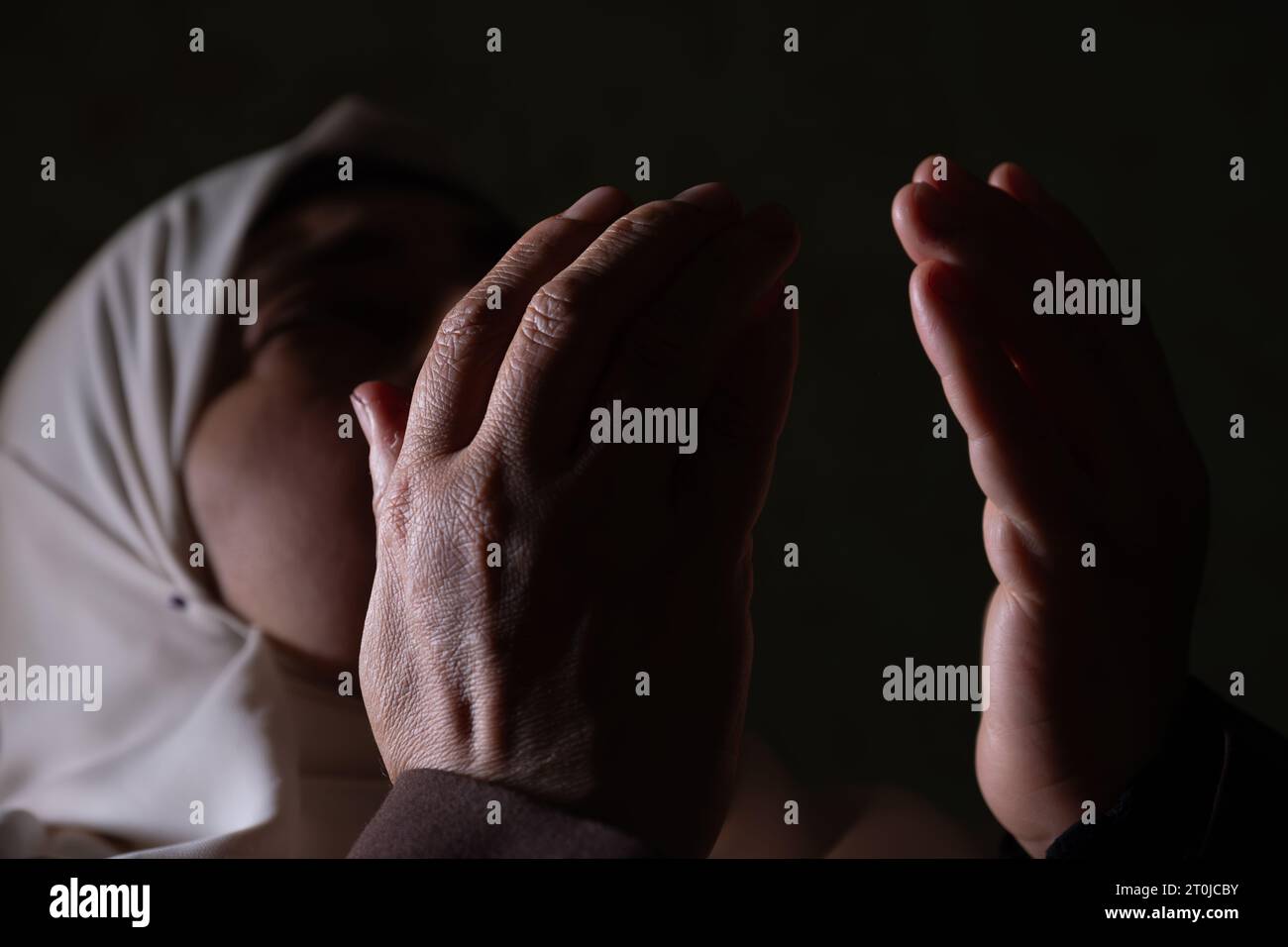 A Muslim woman raises her prayers to God to remove the affliction and ...