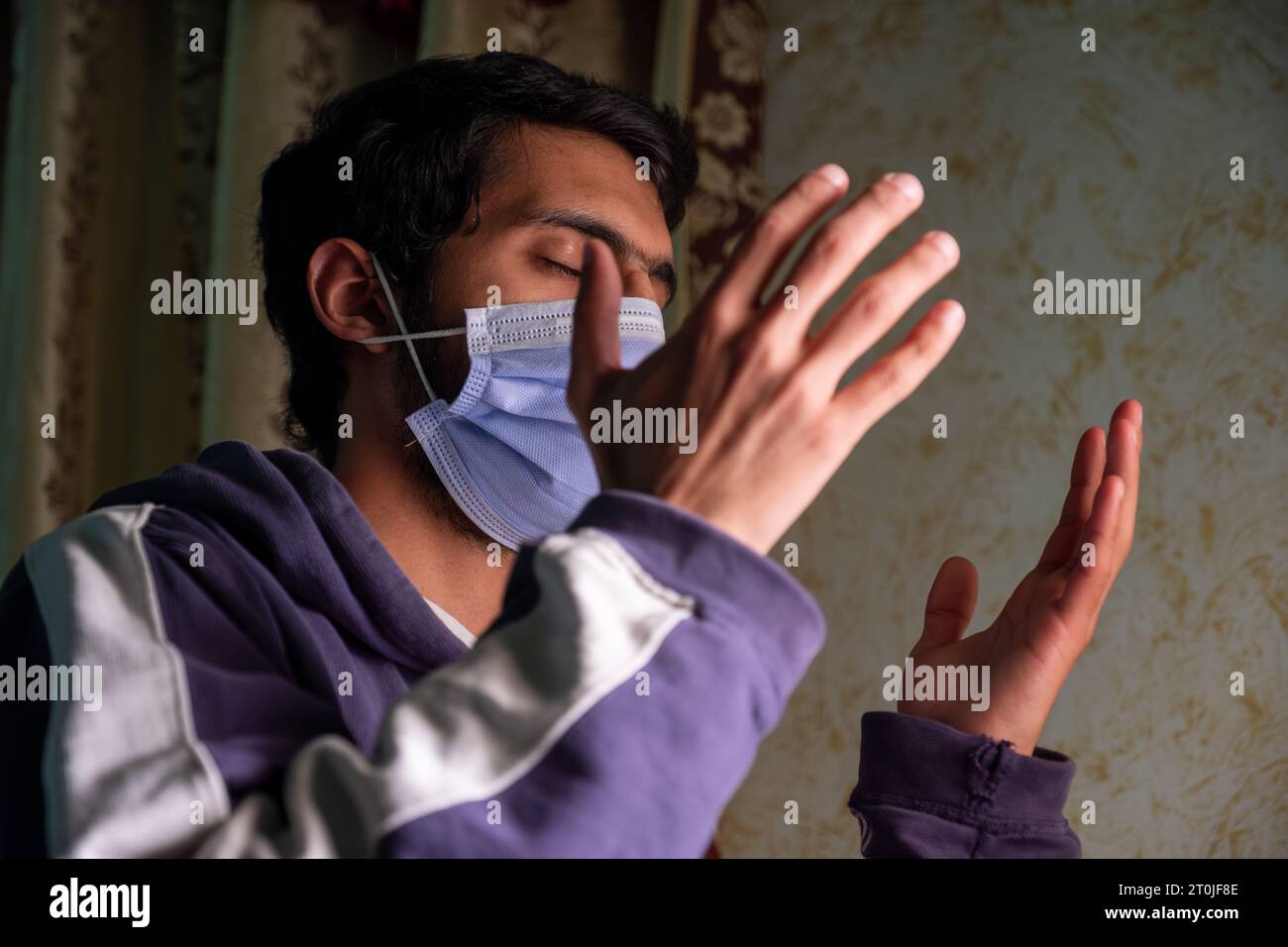 Male wearing mask and praying for allah to protect him from diseases ...