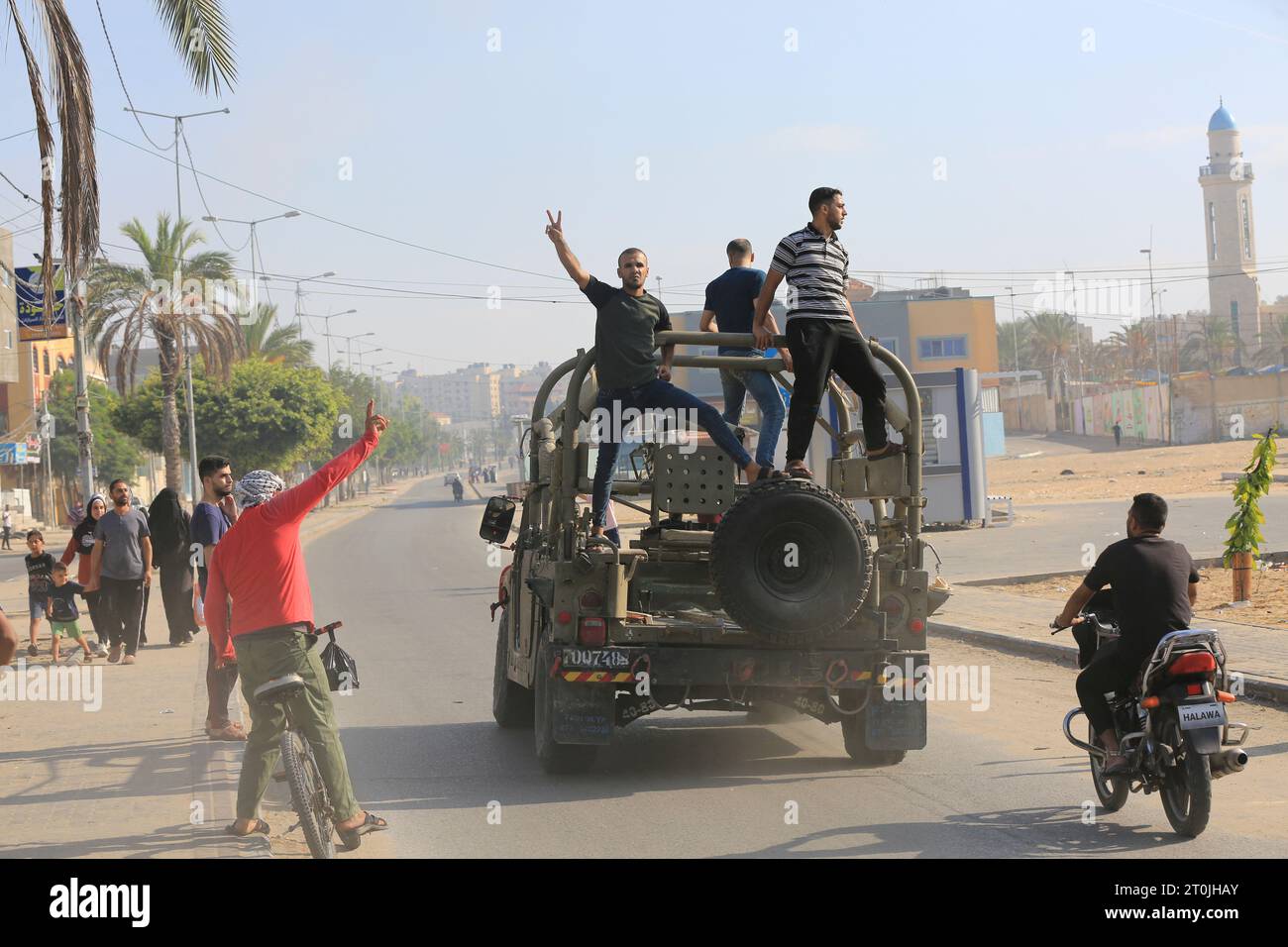Palestinians ride on an Israeli military vehicle taken by an army base ...