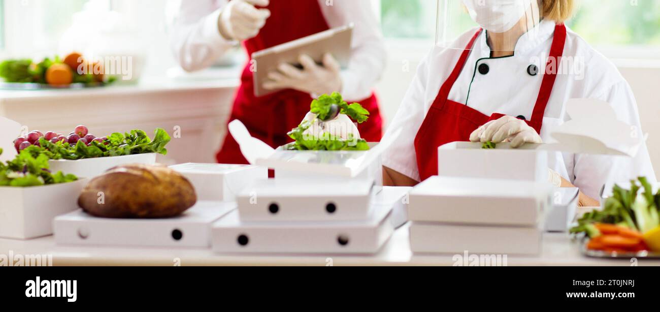 Food takeaway in restaurant. Cafe staff cooking takeout order. Safety ...