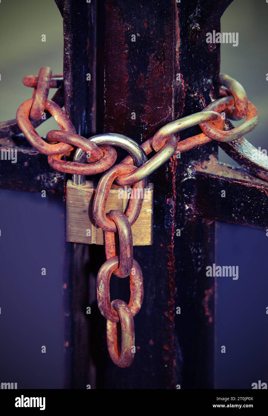 metal padlock with rusty chain that closes a large gate with toned old ...