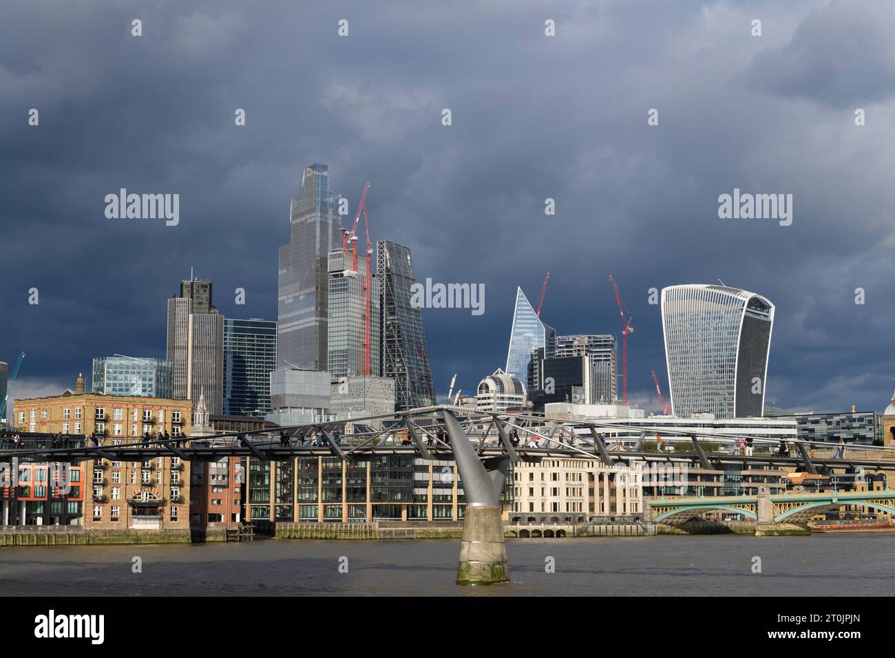 The Millennium footbridge over the River Thames with the Skysrapers of ...